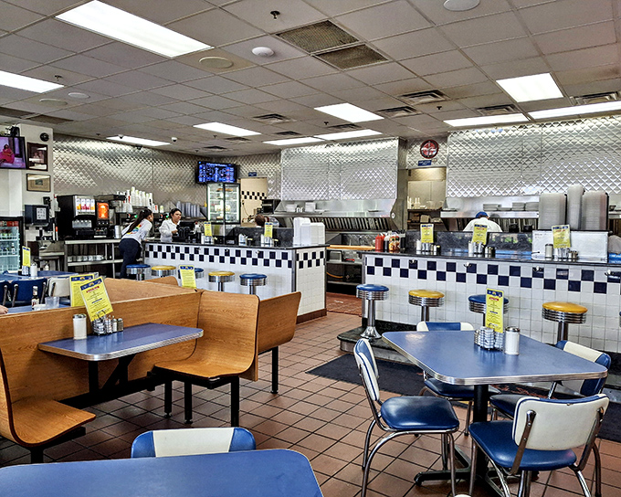 Classic diner geometry at its finest—blue vinyl booths, swivel counter stools, and that unmistakable checkerboard trim. This isn't décor; it's a time machine.