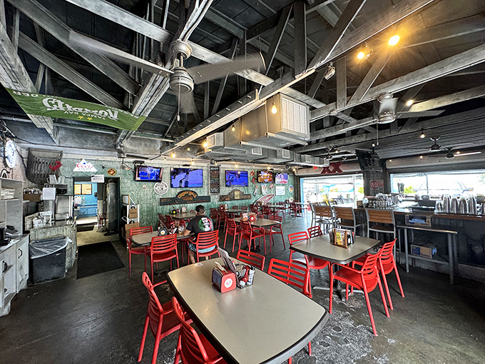 Industrial-chic meets coastal charm inside, where exposed beams and red chairs create the perfect backdrop for seafood feasting without pretension.