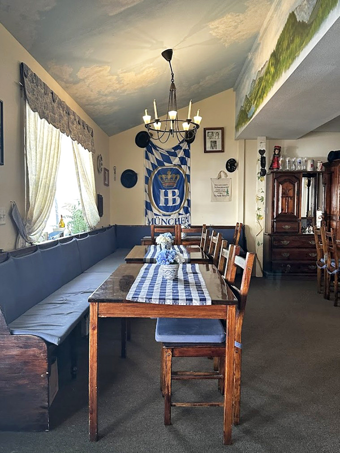 Step inside and you're transported to Bavaria with blue-checkered tablecloths, wooden benches, and an Alpine mural that practically yodels at you.