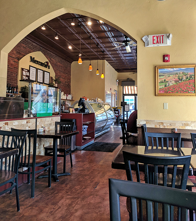 Warm yellow walls meet exposed brick and pendant lighting, creating that perfect "am I in Naples?" atmosphere that makes you instantly hungry.