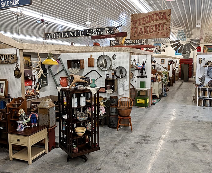 Vintage signs hang from the ceiling like historical stalactites, creating a museum above your head while you navigate the carefully arranged vendor booths below.