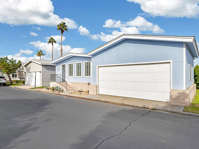 A light blue manufactured home with garage that screams "California living" without whispering "second mortgage." Palm trees included at no extra charge!