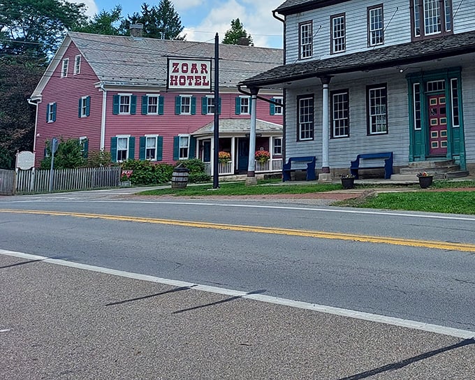 The iconic pink Zoar Hotel stands proudly alongside white clapboard buildings—like the architectural equivalent of Neapolitan ice cream!