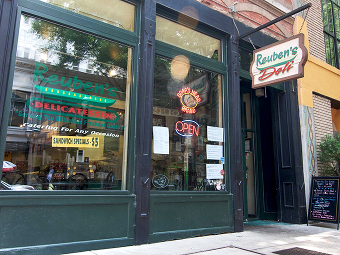 Reuben's storefront whispers of deli history, where sandwich artistry happens behind those green-trimmed windows.