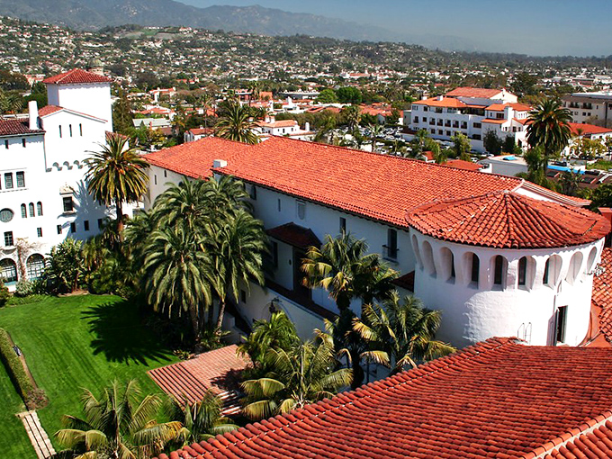 Red tile roofs and white walls create a Spanish colonial dreamscape against mountain backdrops.