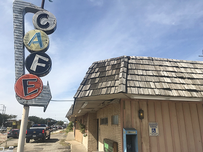 The vintage "CAFE" sign stands tall, promising biscuits that would make your grandmother weep with joy.