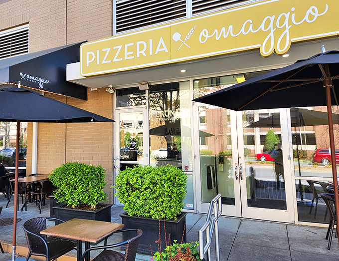 Sleek outdoor seating that whispers "stay awhile" beneath a sign that promises Italian tribute in every bite.