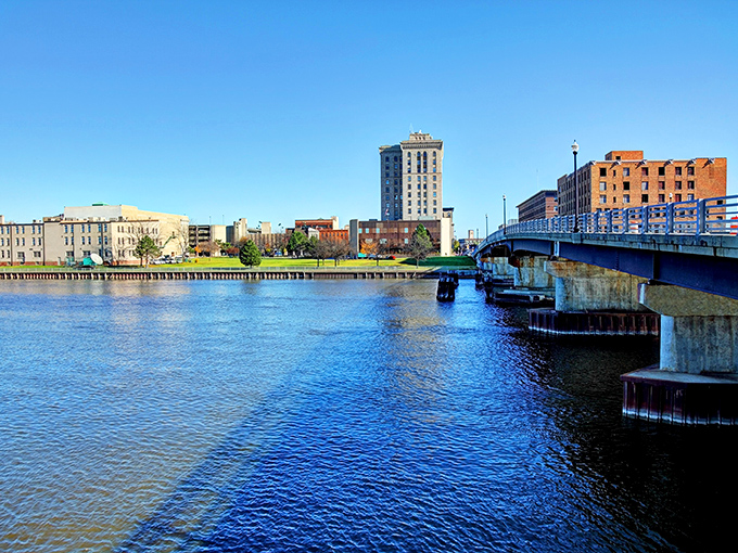 The Saginaw River reflects the city's skyline like a mirror, offering peaceful views that belie the affordable living costs nearby.