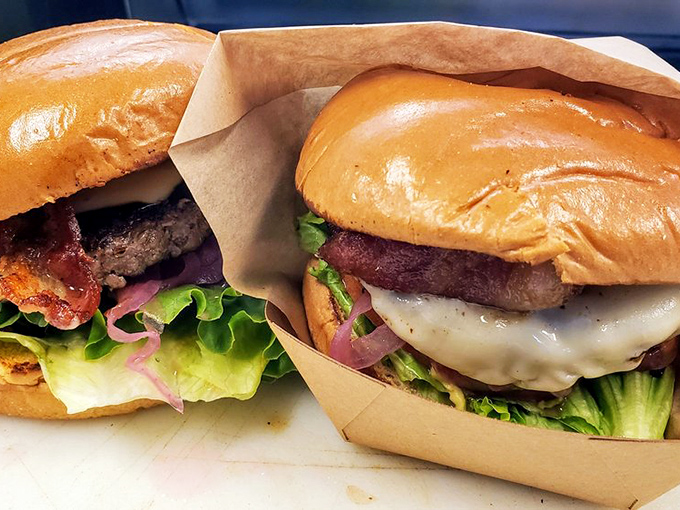 Two burgers that could make a vegetarian question their life choices. The glistening bun, melted cheese, and fresh toppings create edible architecture worth admiring.