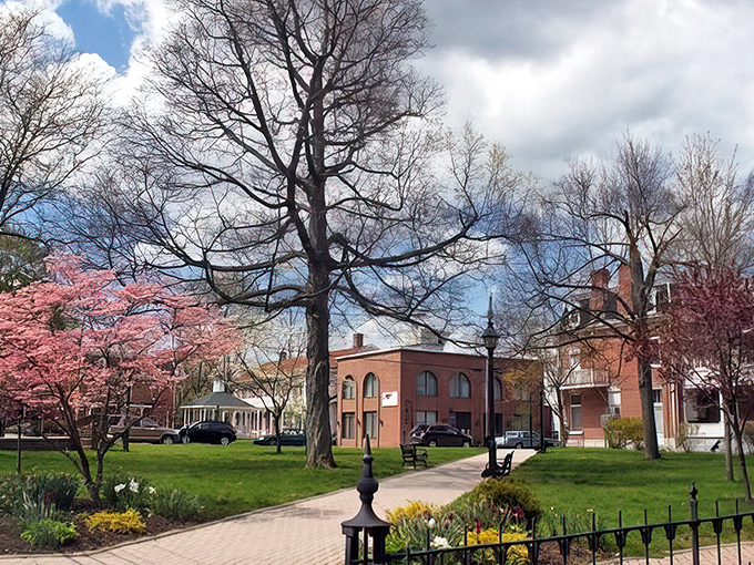Spring blooms frame the town square like nature's own welcome mat for weary travelers seeking charm.