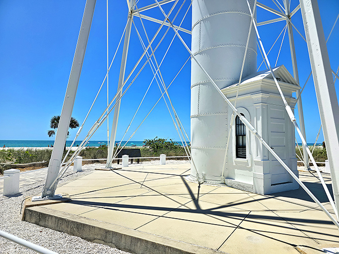 Architectural poetry in white steel &ndash; the lighthouse's skeletal frame creates a geometric dance against the endless blue horizon.