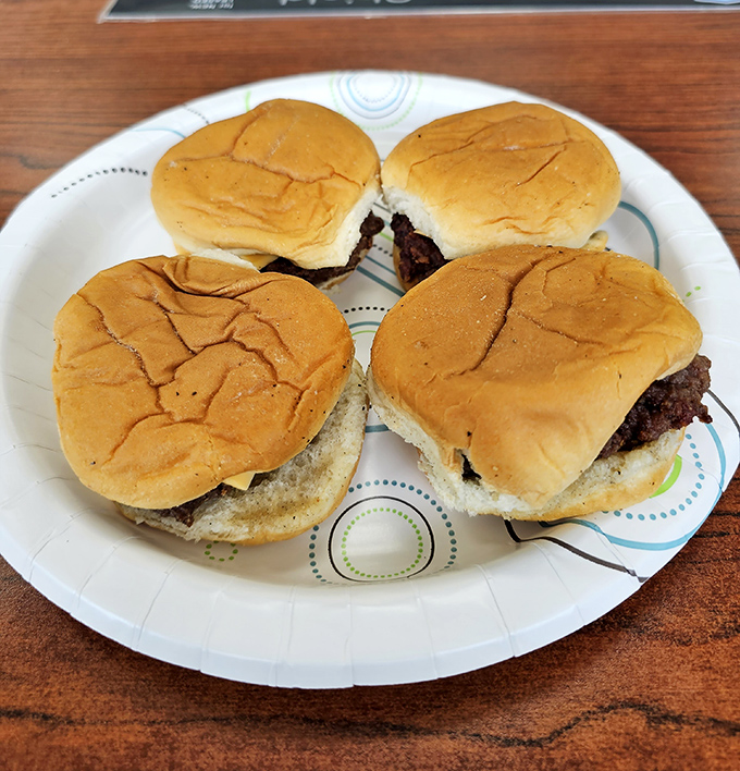 Four perfect sliders await their destiny on a paper plate. Small in stature but mighty in flavor&mdash;the burger equivalent of Danny DeVito.