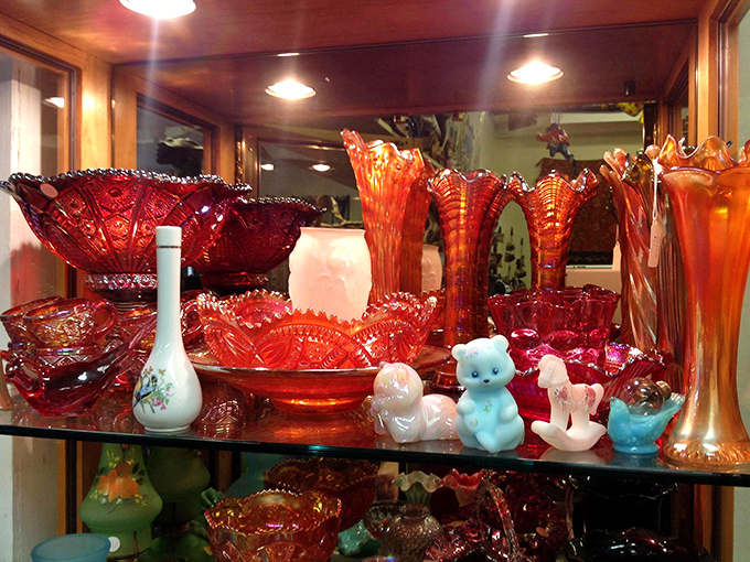 Ruby red carnival glass catches light like liquid fire, transforming ordinary shelves into a dazzling display of vintage artistry.