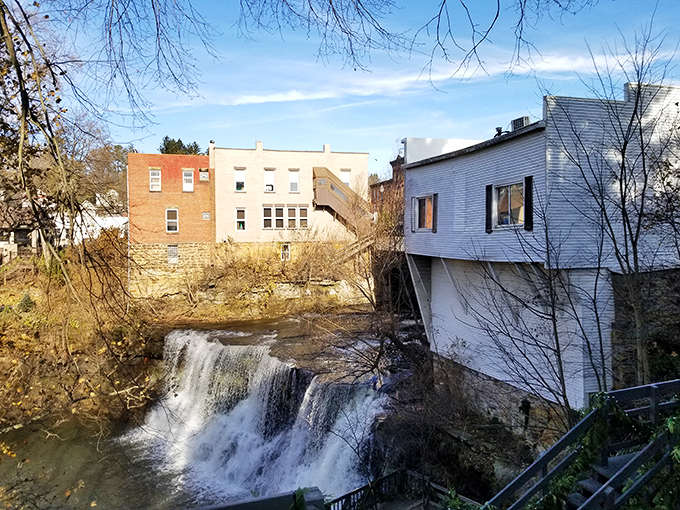 Nature's downtown centerpiece: the falls cascade dramatically between historic buildings, proving water features aren't just for fancy hotels and Vegas casinos.