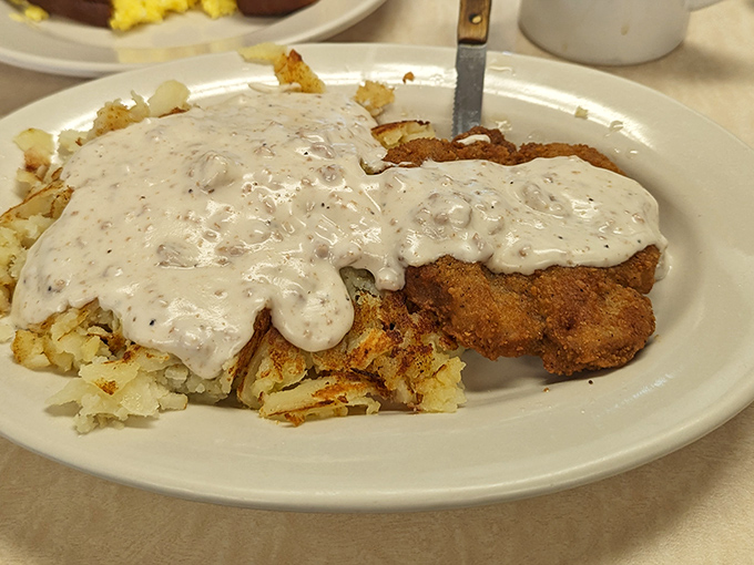Behold the star attraction: country fried steak swimming in pepper gravy that could make a vegetarian question their life choices. This isn't just food&mdash;it's edible therapy.