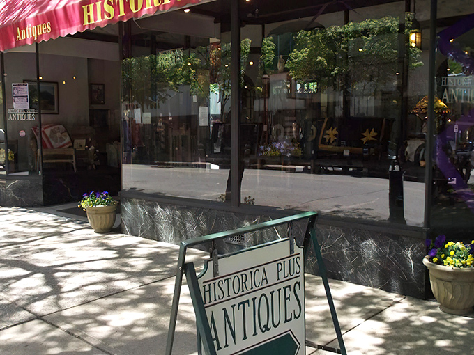 Simple yet inviting, the sidewalk sign promises adventures in antiquing. Flower pots add a touch of life to this portal to the past.