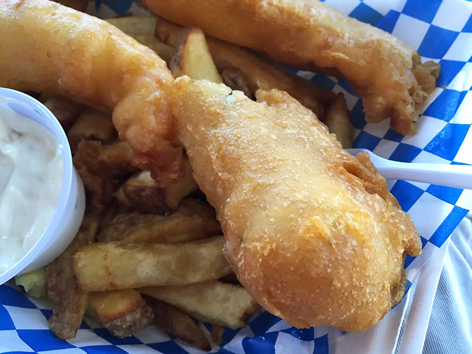 Golden perfection on blue-checkered paper&mdash;the fish practically shatters at first bite while the chips stand ready for their supporting role.