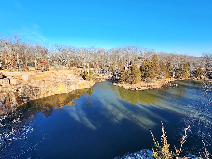 The old quarry pond offers a mirror-perfect reflection, turning the ordinary act of looking at water into a double feature of natural beauty.