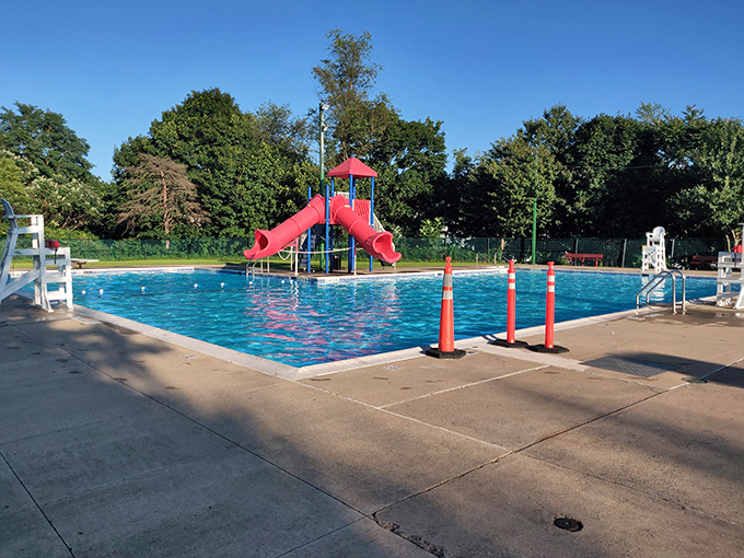 Summer salvation comes in the form of Mount Carmel's community pool, where the red slide promises joy that costs less than a streaming subscription.