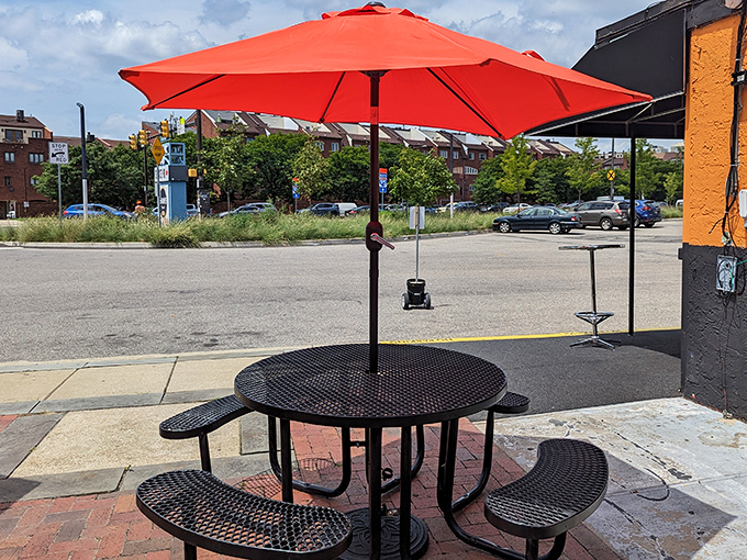 Al fresco dining with a bright red umbrella&mdash;nature's way of saying "the food here is so good, even the sun wants to hang around."