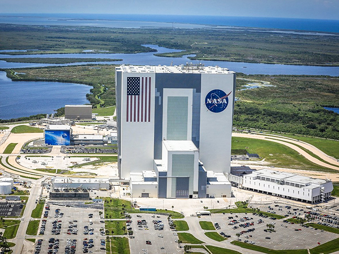 The Vehicle Assembly Building looms like a modern-day Colossus, its American flag a reminder of national pride in space exploration.