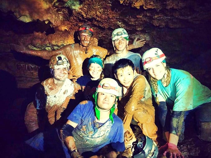 Adventure seekers covered in cave mud after exploring the wild side of Inner Space. Their smiles say it all: sometimes getting dirty is the point.