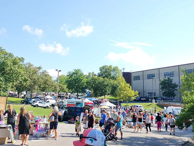 A marketplace symphony in full swing. Vendors, shoppers, and treasure-seekers create the perfect weekend melody against a backdrop of leafy shade trees.