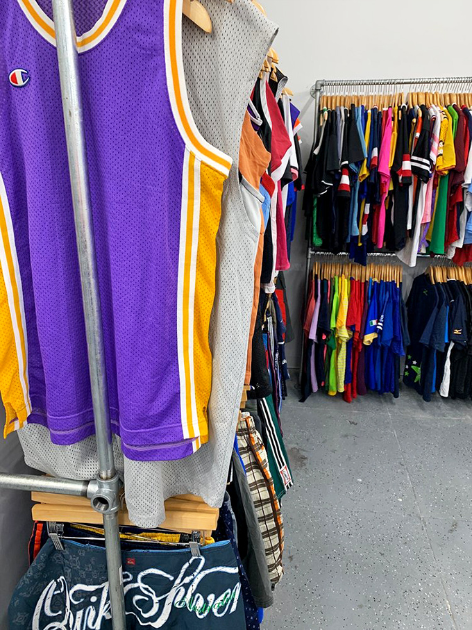 A purple Lakers jersey holds court among colorful neighbors, each garment patiently waiting for its second act in someone's closet.