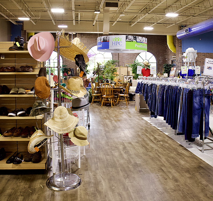 A forest of hats blooms beside neatly organized denim—proof that organization and bargain hunting aren't mutually exclusive concepts.