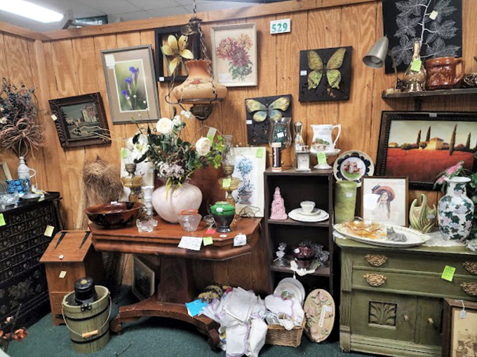 This vendor's booth is a masterclass in organized chaos&mdash;butterfly art, vintage vases, and antique furniture creating a perfectly curated treasure nest.