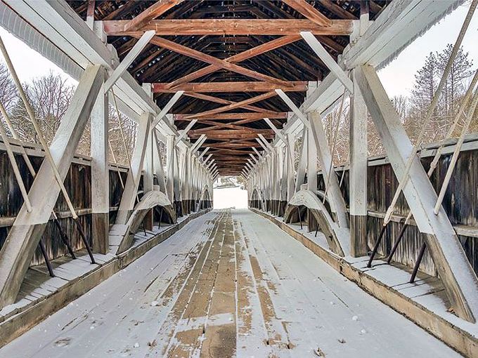 Winter transforms the bridge's interior into a cathedral of wooden beams, where sunlight creates ever-changing patterns on the weathered planks.