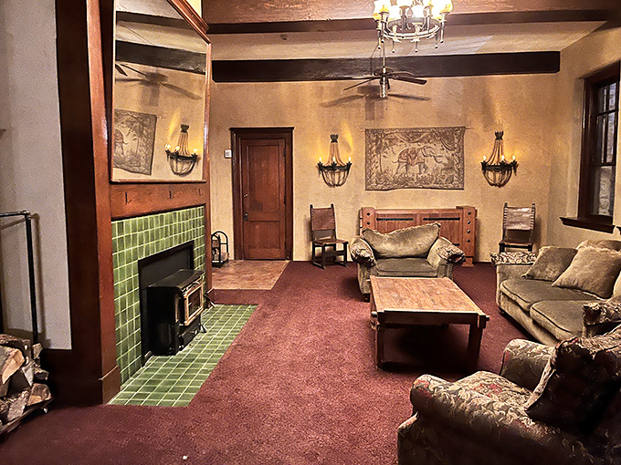 The cozy living room with its distinctive green-tiled fireplace invites visitors to imagine themselves as characters in the castle's century-old story.