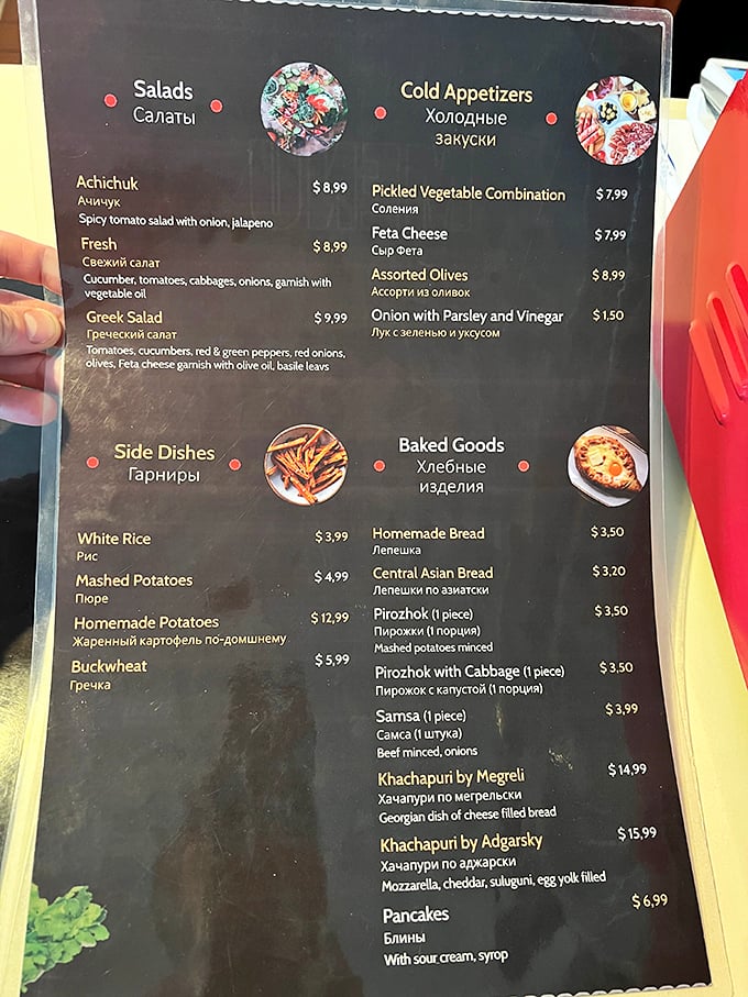 The bilingual menu reads like a passport to the Caucasus. Each Cyrillic-accompanied dish promises a direct flight to flavor country, no TSA required.