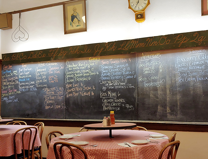 The daily menu chalked on the original blackboard—complete with cursive alphabet above—proves some educational traditions are worth preserving.