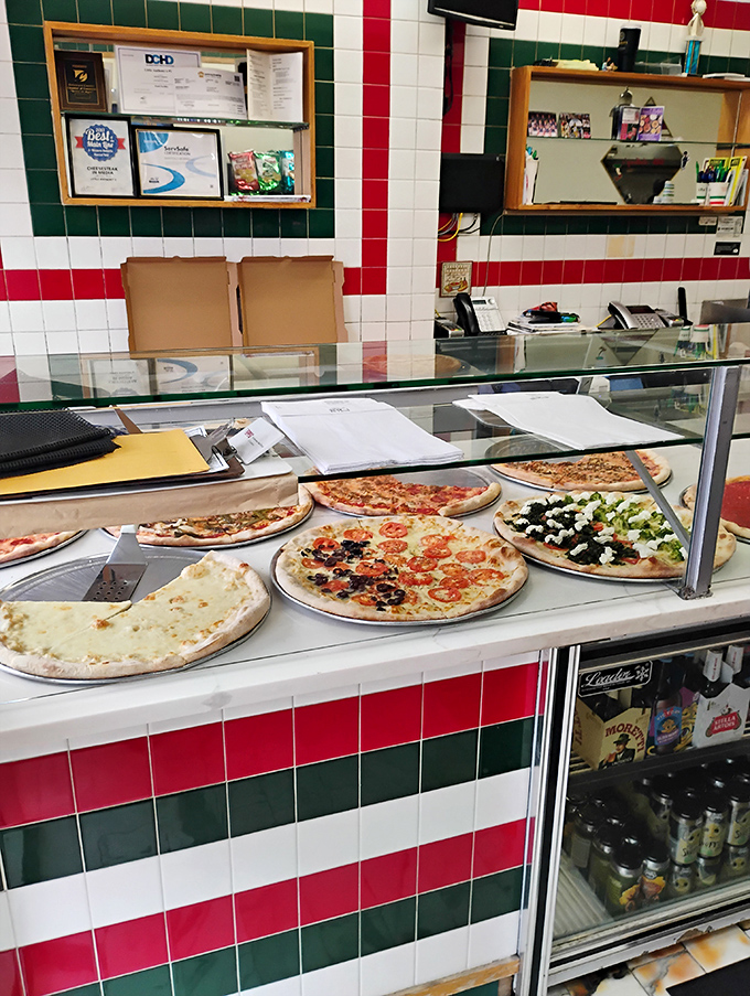 Pizza paradise on display! Each pie waits patiently behind glass like edible works of art, tempting you with possibilities.