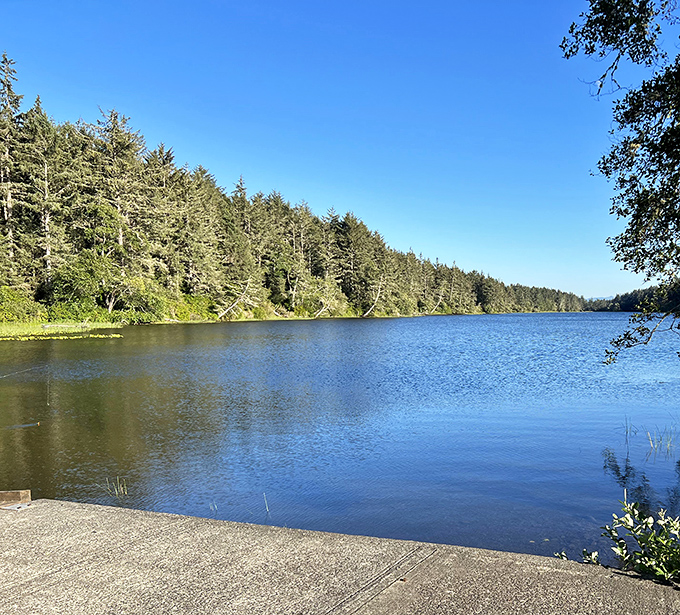 Coffenbury Lake's mirror-like surface reflects the surrounding pines with such precision, you'll wonder which side is the real world.