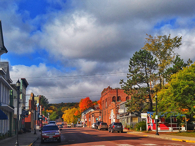 Bayfield's main street bursts with fall colors, the brick buildings glowing warmly in the autumn light against a backdrop of rolling hills.