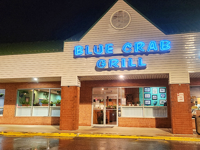 Blue Crab Grill's neon sign glows like a beacon for seafood lovers &ndash; proof that strip malls sometimes hide the most delicious secrets.