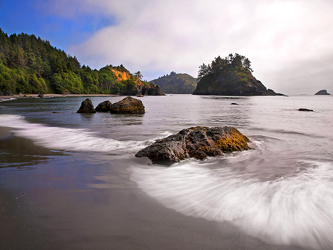 College Cove's emerald waters and dramatic rocks make this beach worth every step of the forest trail.