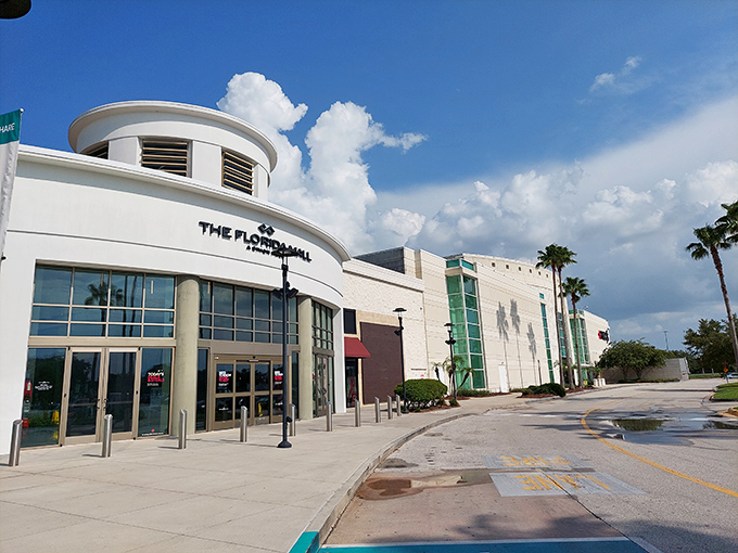 The Florida Mall's sleek, modern entrance stands ready to rescue shoppers from Orlando's afternoon heat with air-conditioned retail bliss.