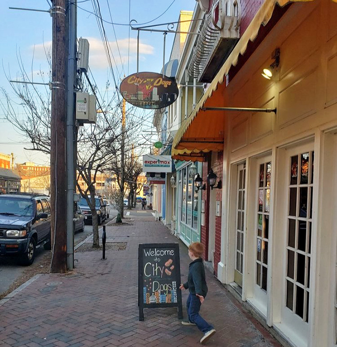 The sidewalk board welcomes hungry explorers into a world where hot dogs become ambassadors from cities across America.