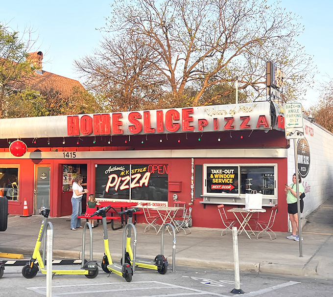 Home Slice Pizza: Where scooters park and pizza dreams come true. That neon "OPEN" sign might be the most beautiful sight in Austin!