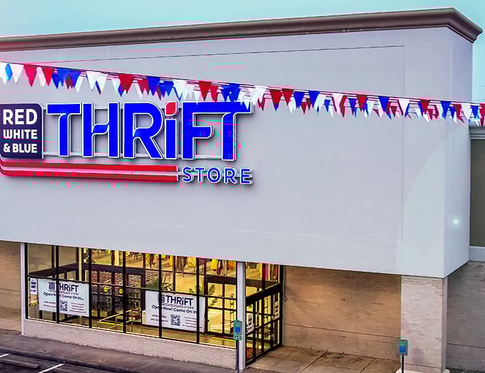 Colorful pennants flutter above Red White & Blue Thrift Store, signaling a festival of secondhand finds inside.