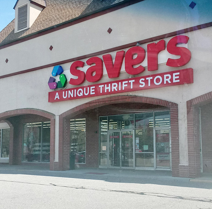 The bright red "Savers" sign pops against the building's neutral tones. A cathedral of castoffs where one person's discard becomes another's treasure!