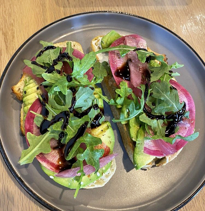 Avocado toast elevated to an art form. Peppery arugula and pickled red onions transform this millennial cliché into something worth crossing town for.