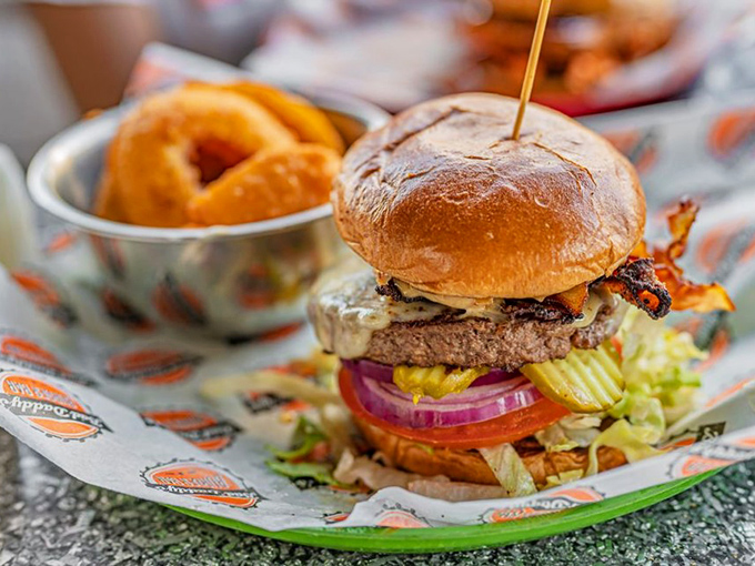 This isn't just a bacon cheeseburger; it's a towering monument to the art of excess, complete with onion rings standing guard.
