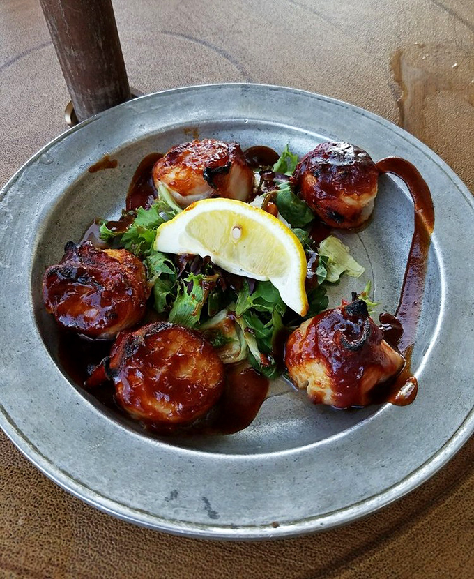 These bacon-wrapped scallops aren't just appetizers&mdash;they're little flavor bombs of sea-meets-land perfection, glazed with what must be colonial-era magic.