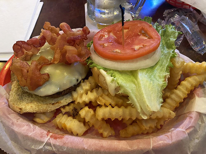 Behold the bacon cheeseburger in all its glory! Melted cheese cascading over the patty like a dairy waterfall, with crispy fries standing guard.
