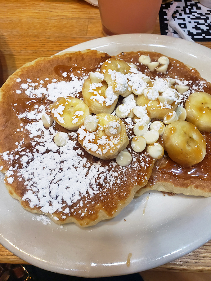 Behold the star attraction: banana pancakes dusted with powdered sugar. Breakfast nirvana achieved in fluffy, caramelized perfection.