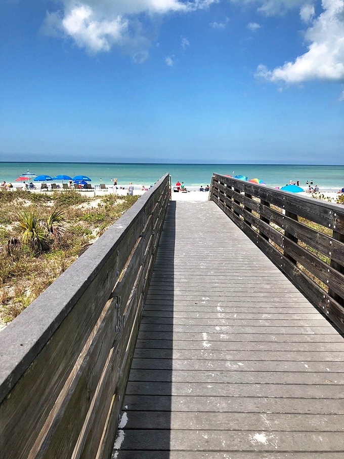 Wooden walkways lead to sandy adventures, proving that the best journeys start with simple steps.